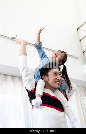 Parent and child riding on each other's shoulders at a park Stock Photo ...