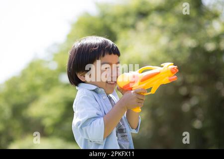 Boy taking aim with water pistol Stock Photo - Alamy