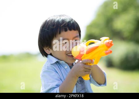 Boy taking aim with water pistol Stock Photo - Alamy