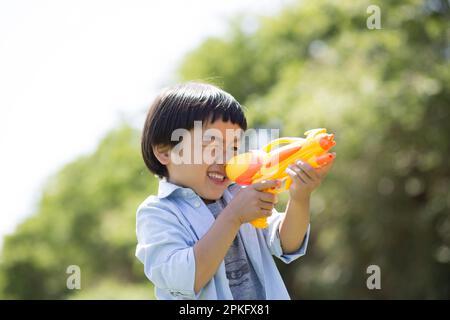 Boy taking aim with water pistol Stock Photo - Alamy