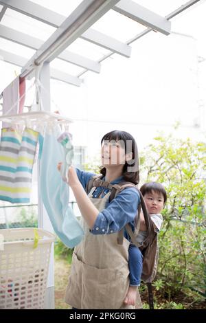 Parent and child drying laundry Stock Photo - Alamy
