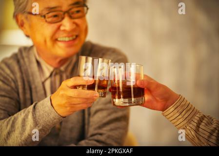 Parent and child making a toast with whiskey Stock Photo - Alamy