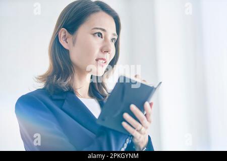 Woman taking notes seriously while standing Stock Photo - Alamy