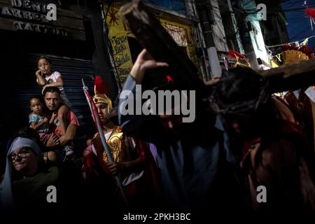 Residents watch a Way of the Cross reenactment at the Complexo do ...