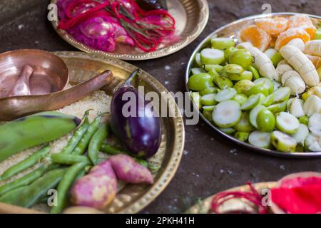 Various fruits and vegetables are kept together in brass plates for ...