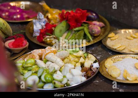 Various fruits and vegetables are kept together in brass plates for ...