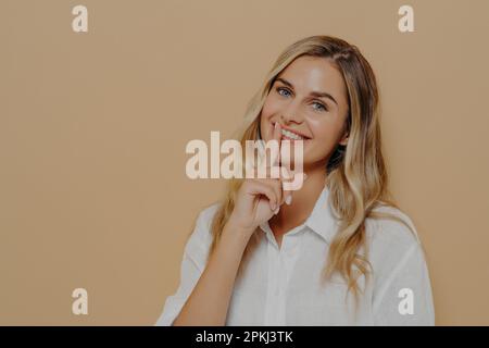Keep quiet sign. Portrait of a beautiful woman in casual clothing ...