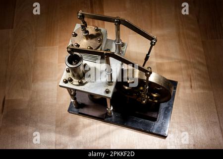 closeup of a stirling engine construction with wooden table and black ...