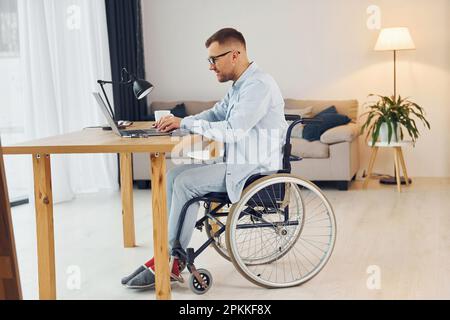 Smart freelance worker. Disabled man in wheelchair is at home Stock ...