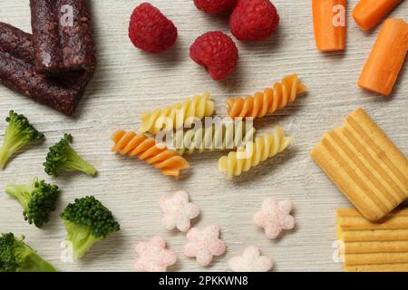 Set of different finger foods for baby on beige wooden table, flat lay ...