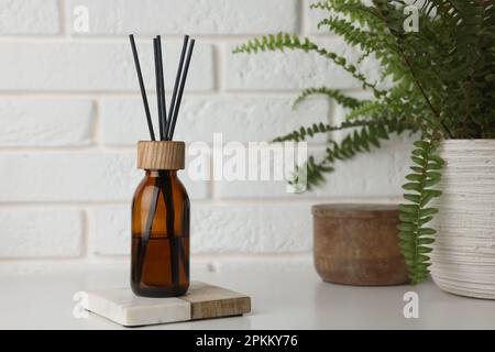 Air reed freshener on table against white wall Stock Photo - Alamy