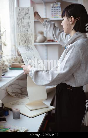 female artist look at her work drawing with pen and black ink. Graphic ...