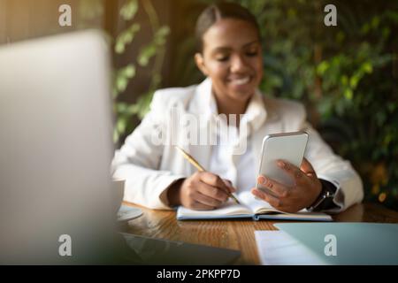 Blurred African American female reading interesting book on sofa on ...