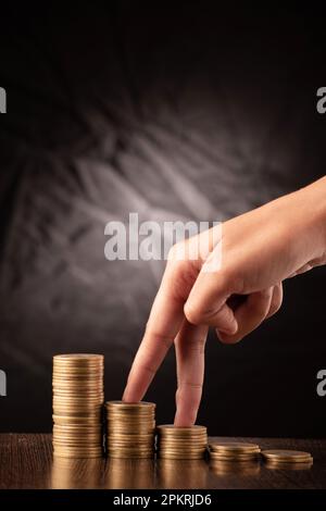 Finger stepping to coin stack Stock Photo - Alamy