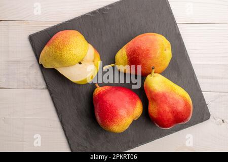 Three whole and Two halves of juicy pears on a serving plate of slate ...