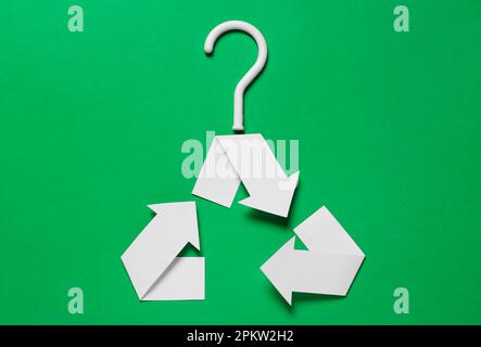 Recycling symbol in shape of hanger on green background, top view ...