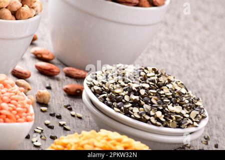 Black split gram in bowl on white background, uncooked urad chilka dal ...