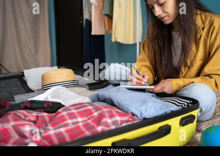 woman traveler prepare things into suitcase for holiday vacation Stock ...
