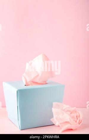 Light blue tissue box and crumpled tissues on blue background. Cold and ...
