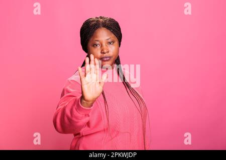 Irritated model doing stop symbol with palm expressing refusal and ...