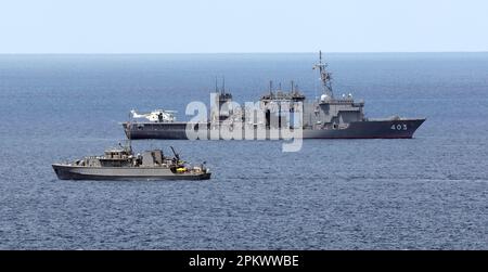 The Shishijima (background), a minesweeper vessel, and the Chihaya, a ...