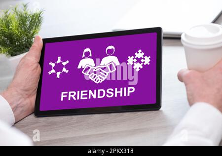 Tablet screen displaying a friendship concept Stock Photo - Alamy