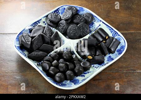 Dutch licorice candies on a Delftware plate isolated on white ...