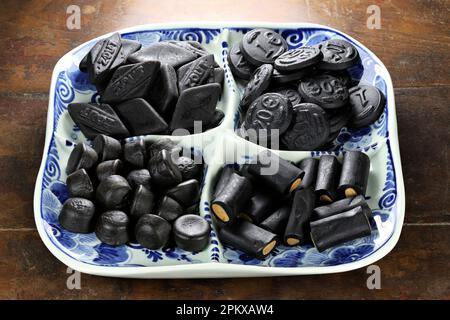 Dutch licorice candies on a Delftware plate isolated on white ...