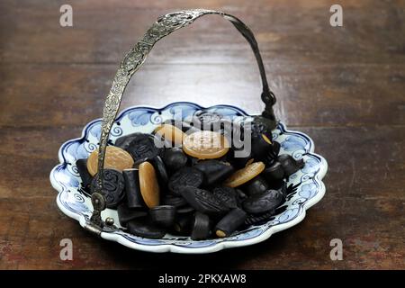 Dutch licorice candies on a Delftware plate isolated on white ...