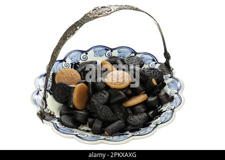 Dutch licorice candies on a Delftware plate isolated on white ...