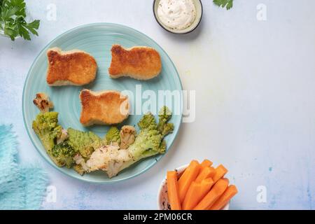 Kids food. Fish shaped nuggets with vegetable Stock Photo - Alamy