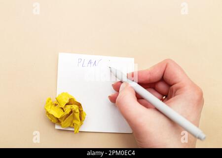 crumpled yelllow paper with a pen and note for writing on beige ...
