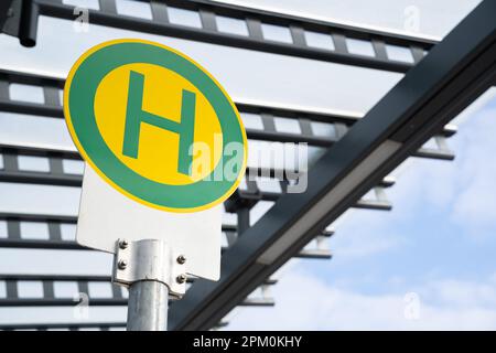 Round green and yellow bus stop sign with the letter H in germany Stock ...