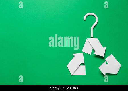 Recycling symbol in shape of hanger on green background, top view Stock ...