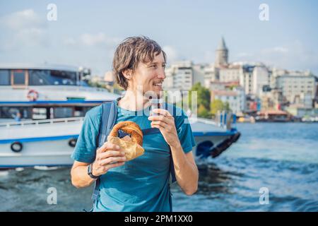 Man in Istanbul having breakfast with Simit and a glass of Turkish tea ...