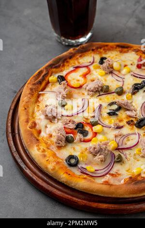 Pizza with tuna, olives, onions, mozzarella cheese and tomato sauce on ...