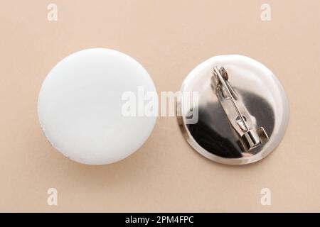 Blank white badges on beige background Stock Photo - Alamy
