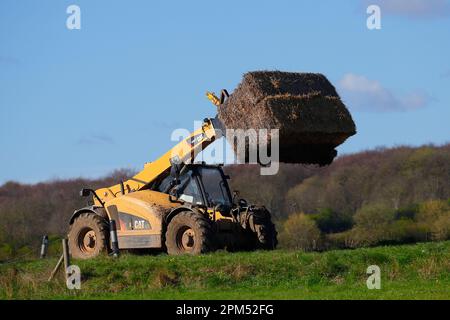 A Caterpillar telescopic handler TH337C travelling along the B1222 near ...