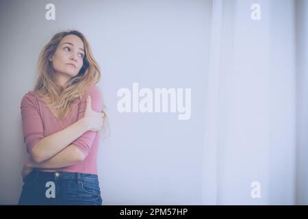 Depressed mid-aged woman at home feeling sad, lonely, anxious (color ...