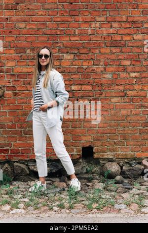 Woman stand near old building with columns and tropical plants in ...