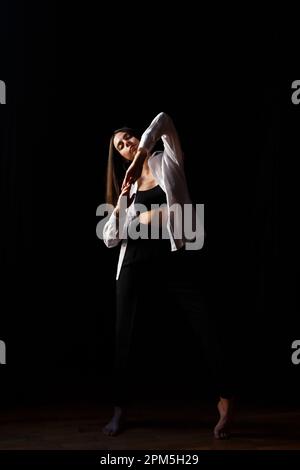 brunette actress dances barefoot in the rehearsal hall of the theater ...