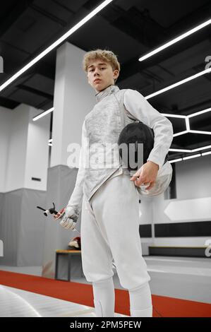 Portrait of confident teenage boy fencer with sharp sword Stock Photo ...