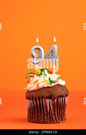 Birthday cake with number 94 candle - Sparkling orange background with ...