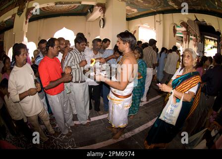 Indian temple ceremony, priest passing around trays with holy flame for ...