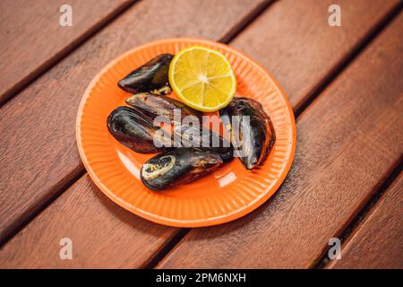 Heap of mussels in shells stuffed with rice and served with lemon. Man ...