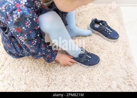 Little girl taking off her shoes Stock Photo - Alamy