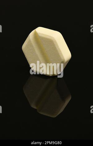Hexagonal pills on light black acrylic background. Extreme closeup ...