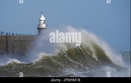 Waves crash around the lighthouse on the harbour arm in Folkestone ...