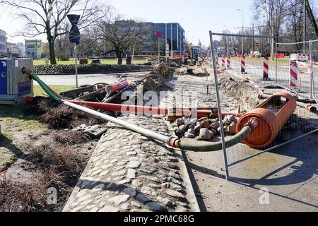 Street repair works site dewatering system with water pump, pipes and ...