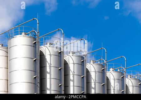 Stainless steel silos against the blue sky. Warehouses for storage of ...